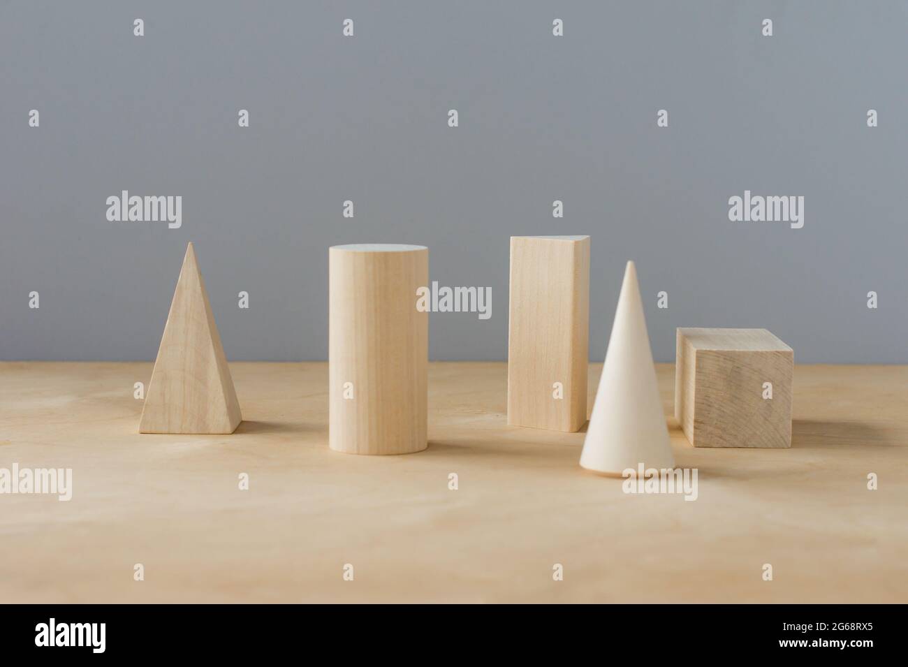 wooden geometric shapes on a grey background with copy space. preschool ...
