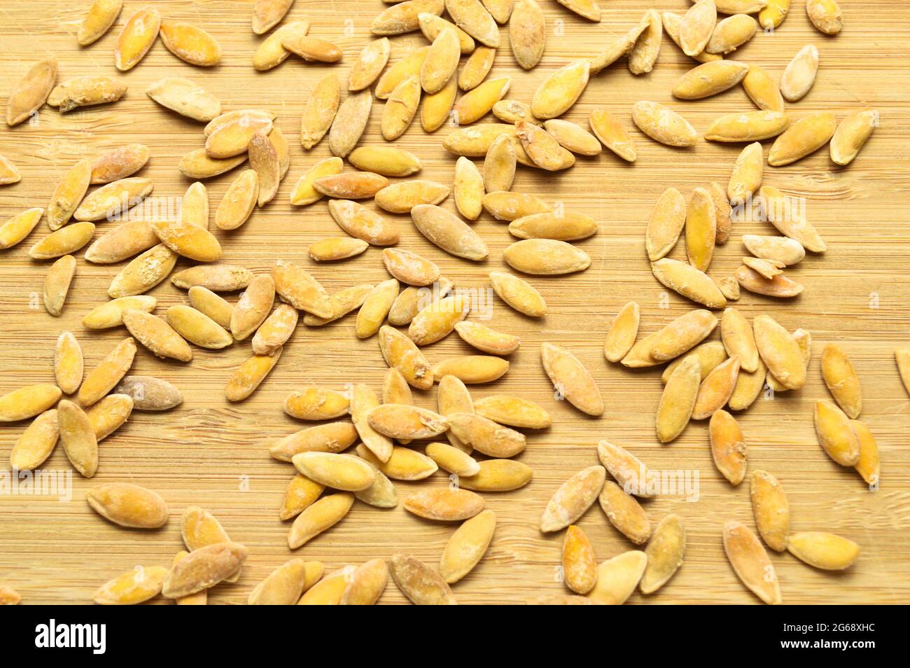 Roasted salted organic dry melon seeds, on bamboo cutting board Stock ...