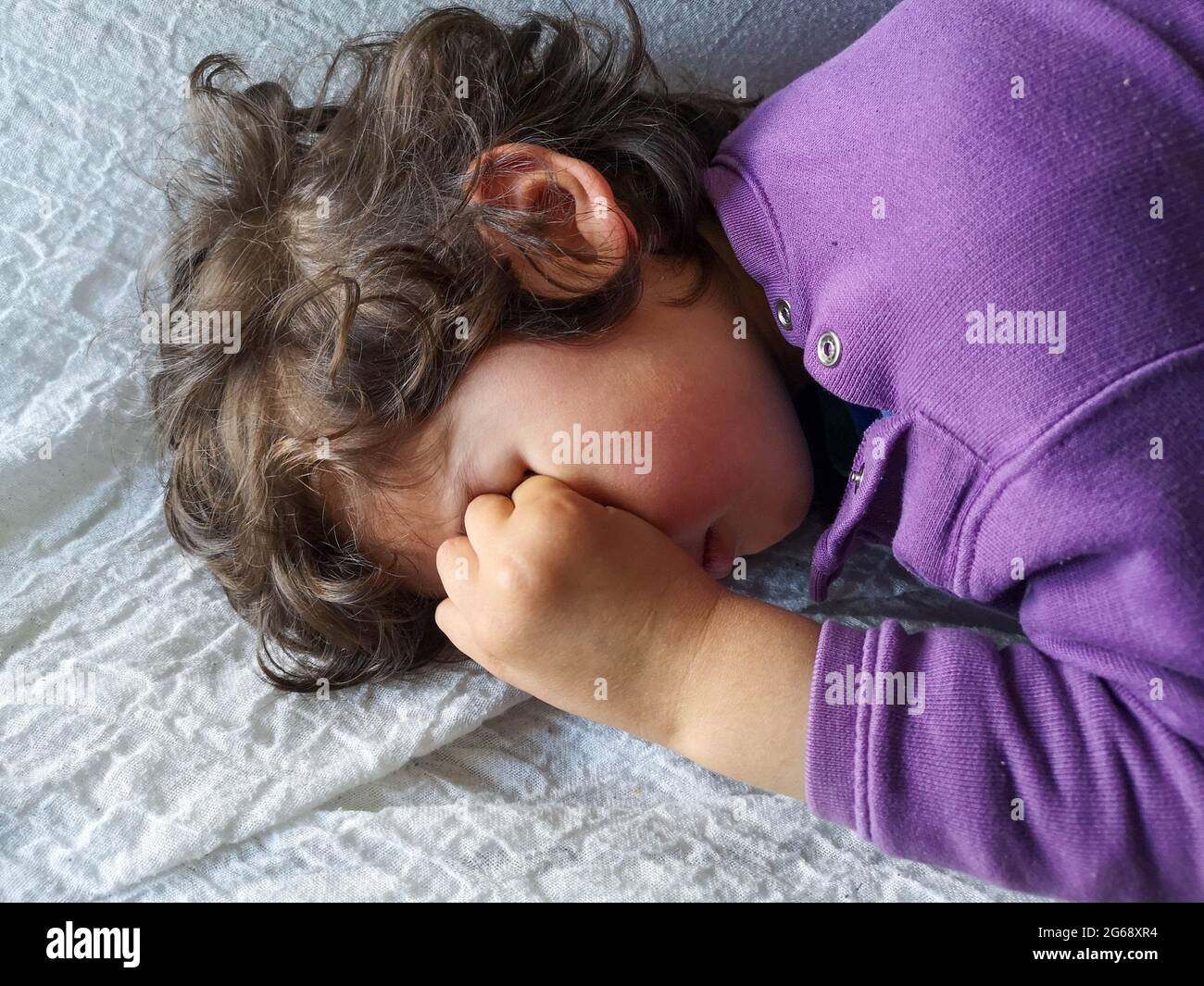 Cute boy tries to wake up and cry on bed Stock Photo - Alamy