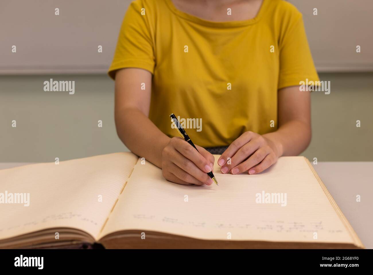 lady write on an old book with worm damage with a pen Stock Photo - Alamy