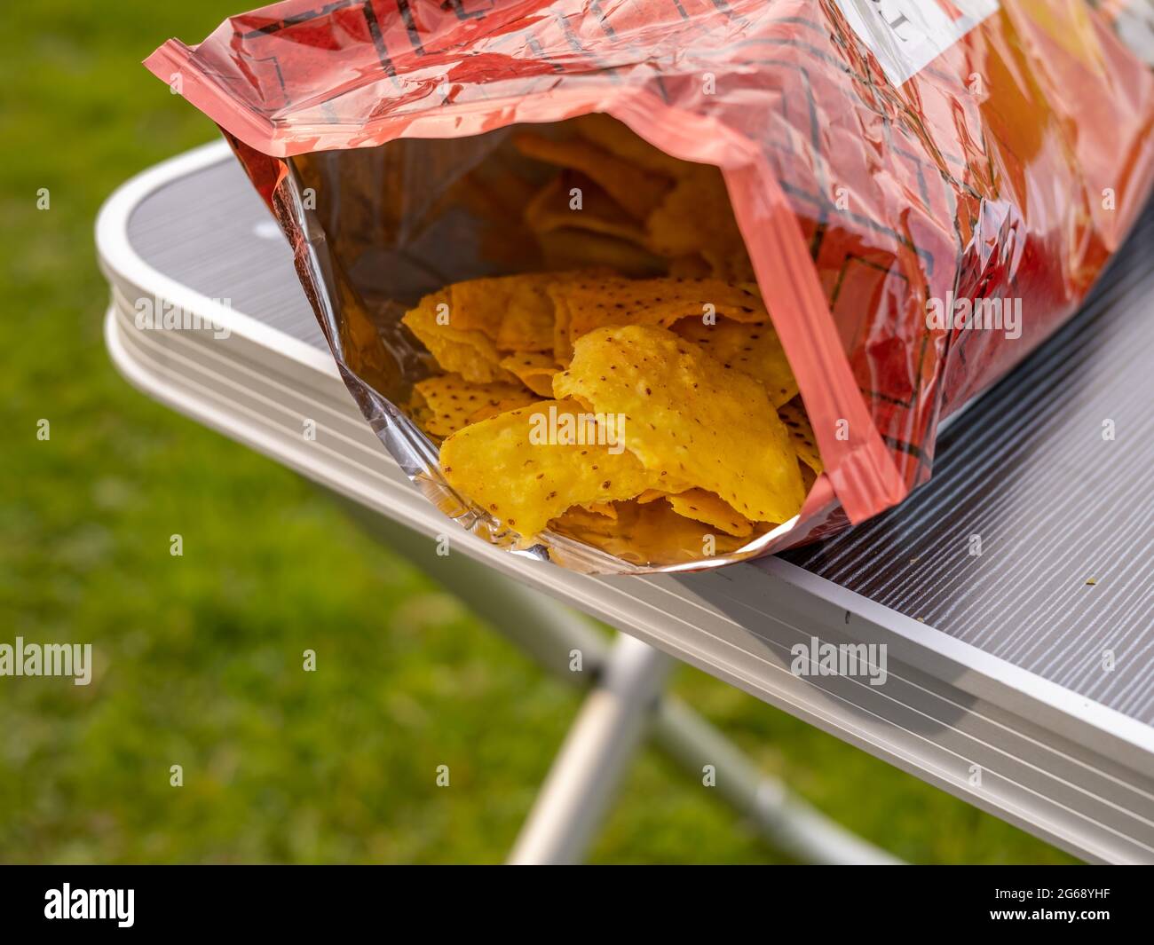 Open packet of sweet chilli crisps on a a table. Seelctive focus ...