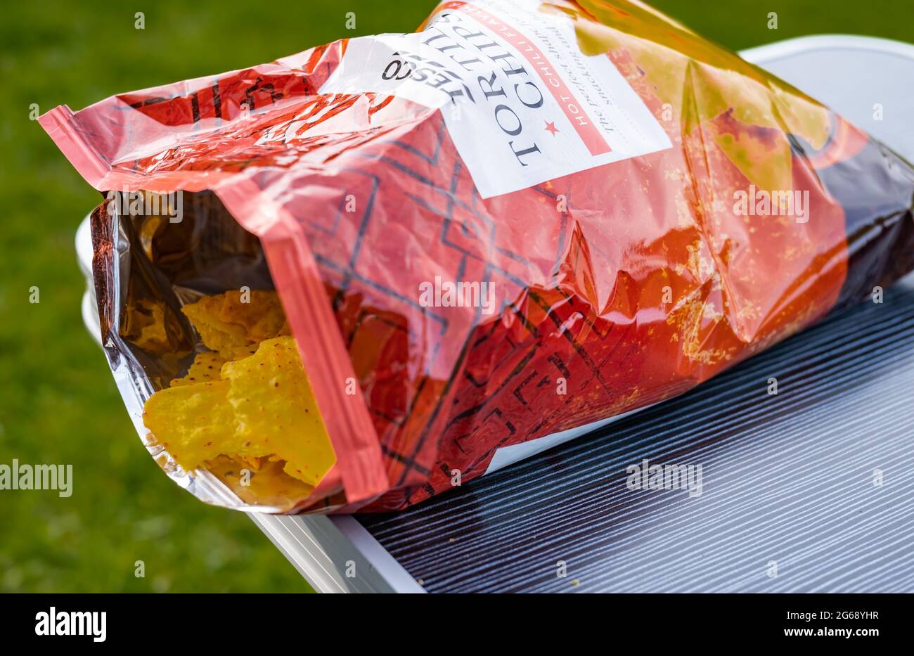 Open packet of sweet chilli crisps on a a table. Seelctive focus ...