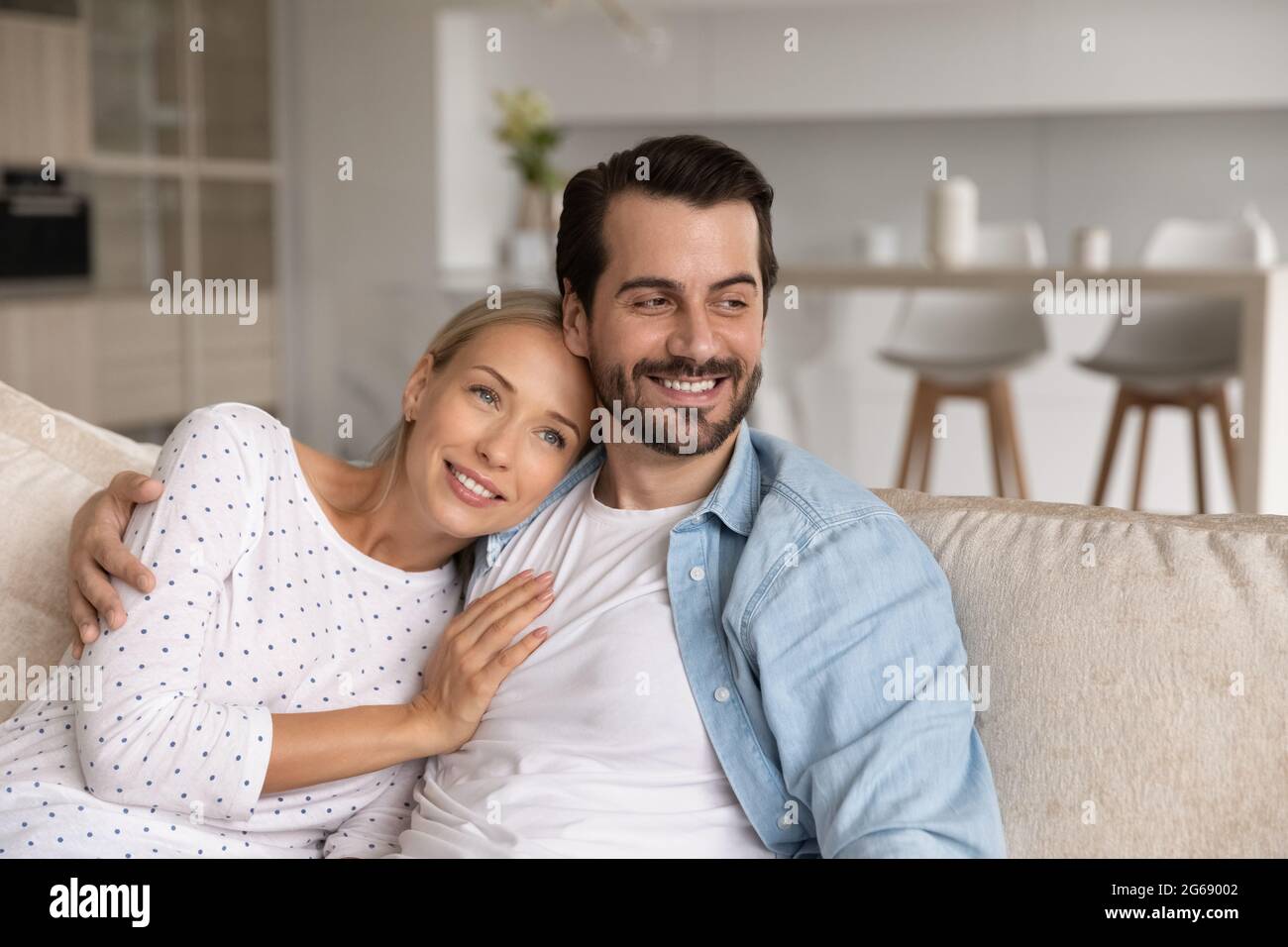 Close Up Dreamy Happy Couple Hugging Relaxing On Couch Together Stock