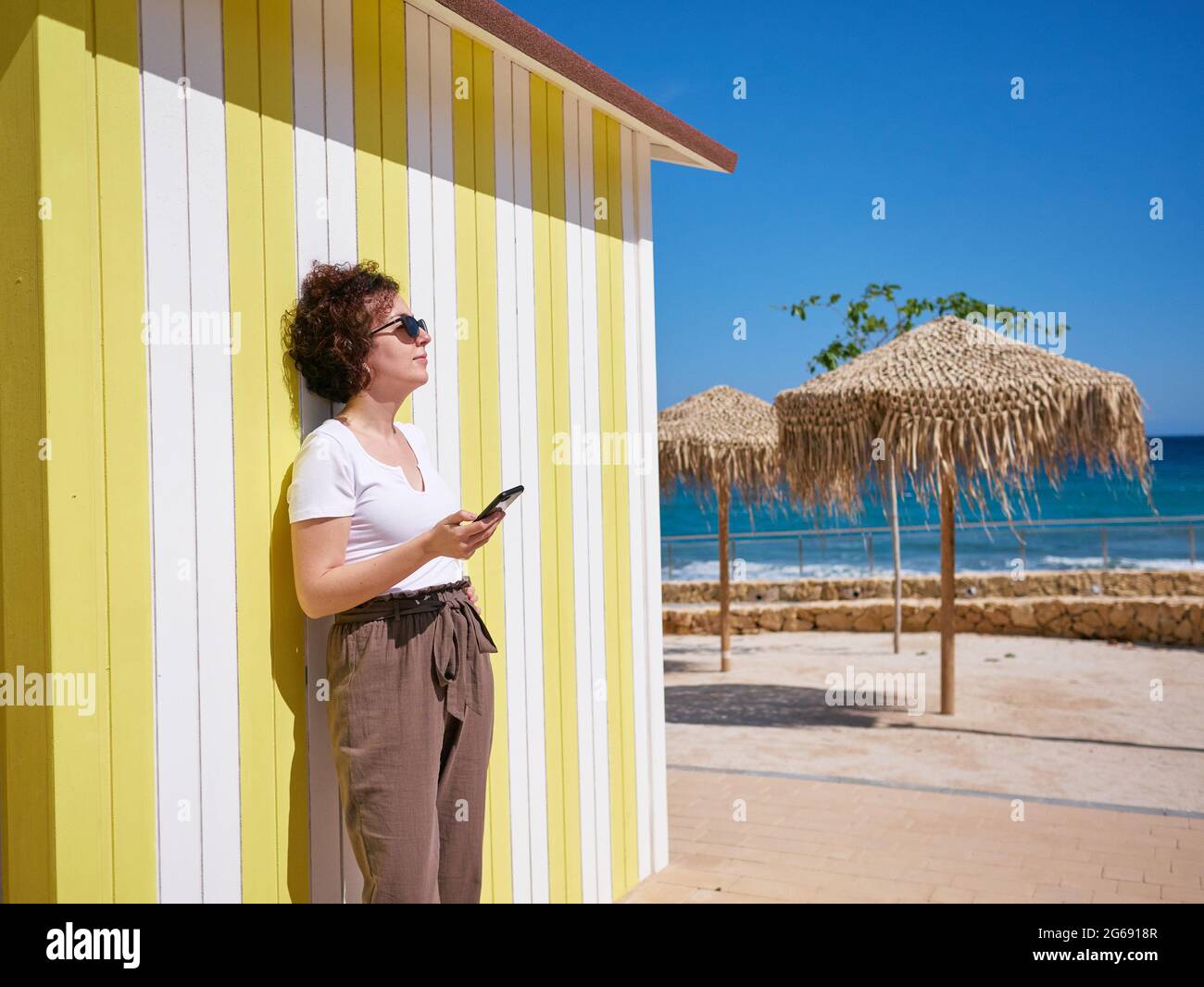 Woman using the phone during her summer vacation Stock Photo - Alamy