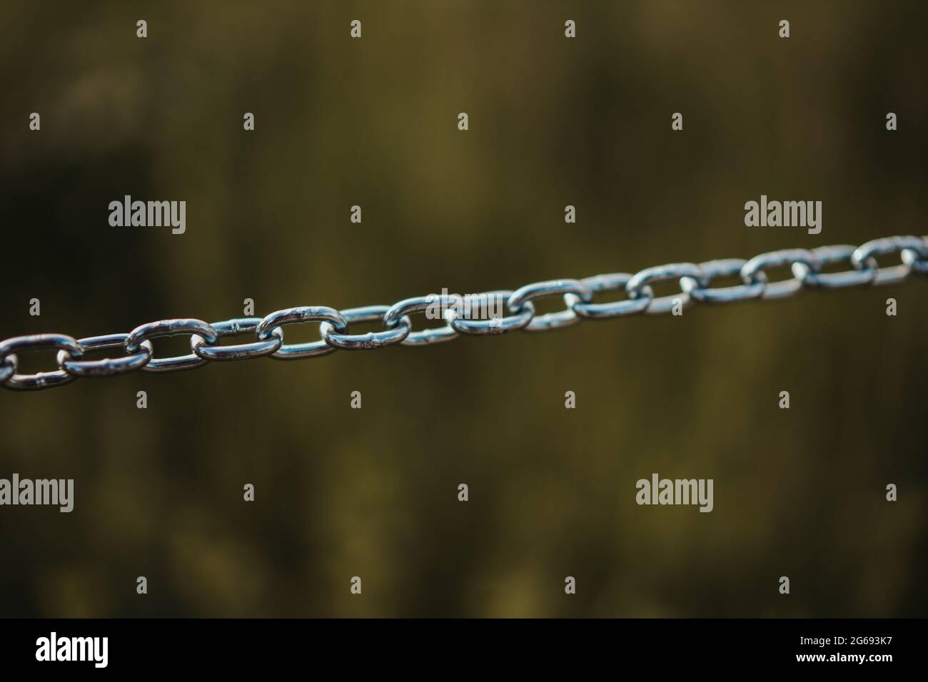 A shallow focus of metal chain on blurred green background Stock Photo ...
