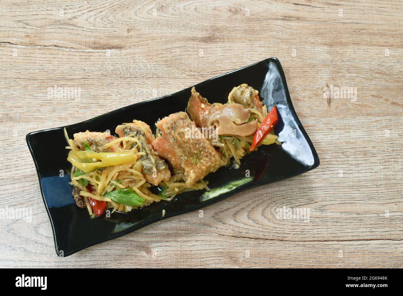 deep fried slice striped snake head fish with ginger and celery on dish ...
