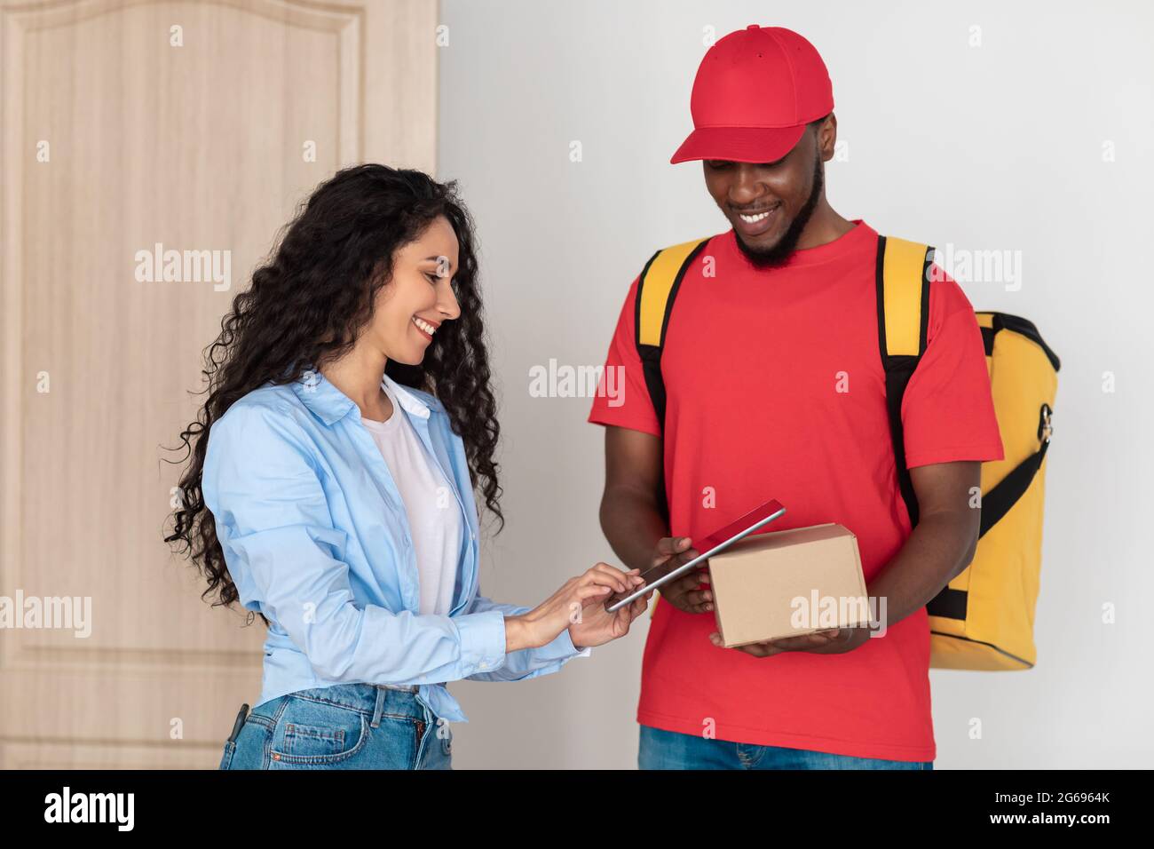 Female Customer Receiving Order Signing Digital Form Standing At Door ...
