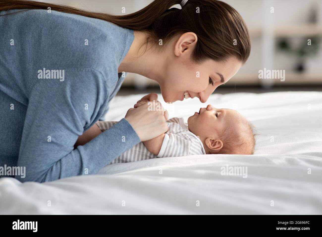 Positive Parenting. Loving Young Mommy Bonding With Newborn Baby At ...