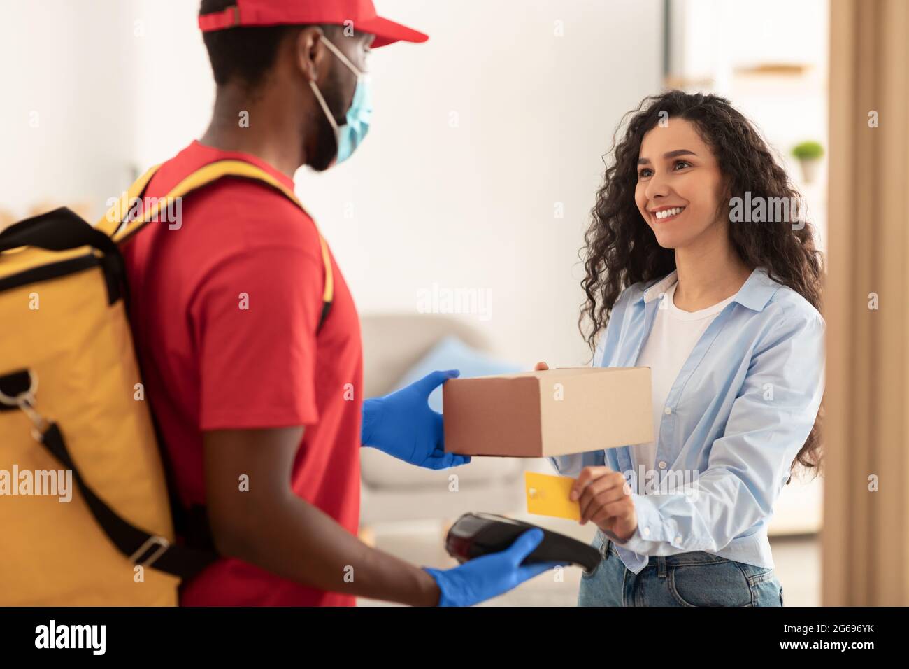 Black man holding POS machine lady paying with debit card Stock Photo ...
