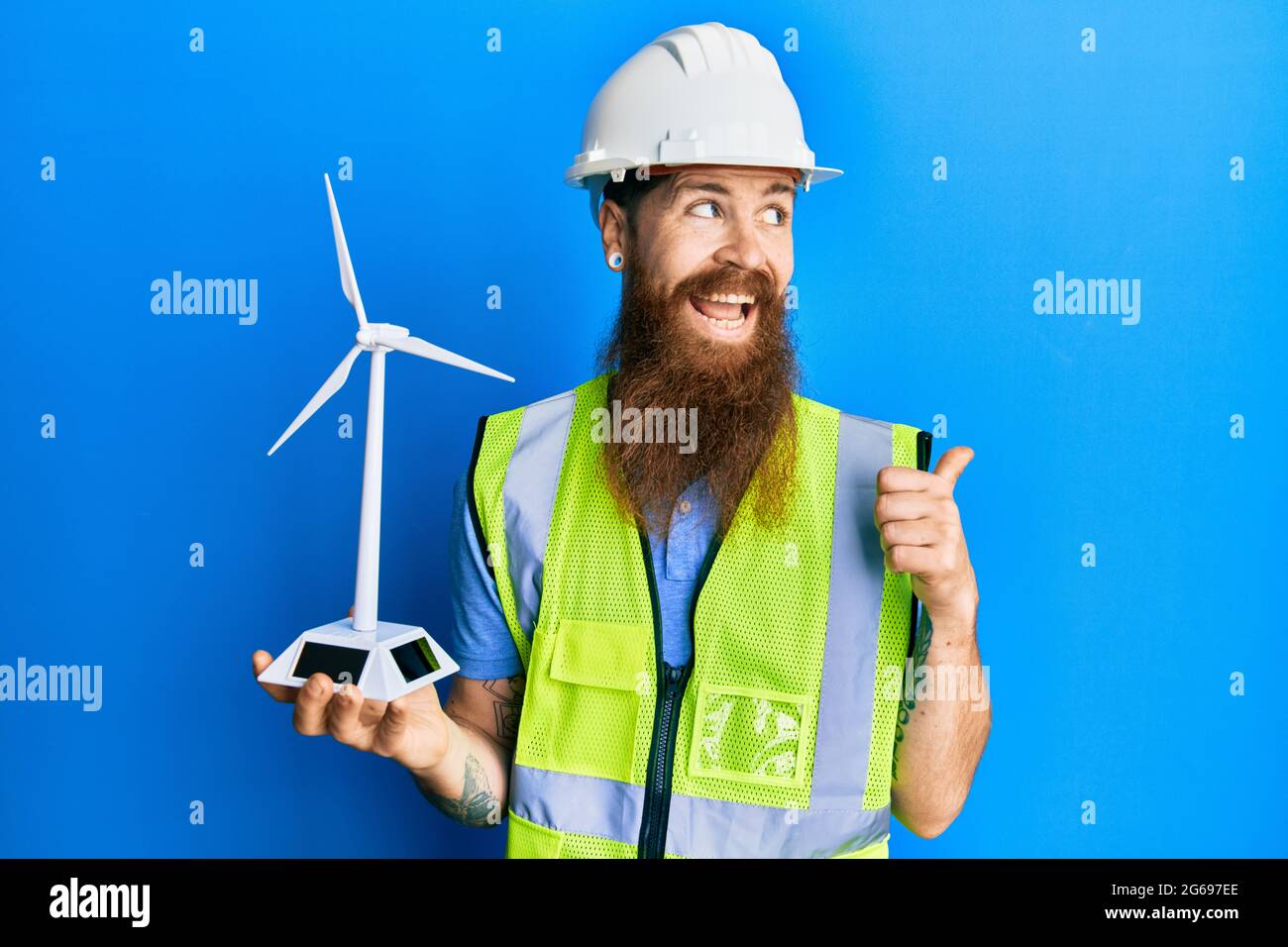 Redhead man with long beard holding solar windmill for renewable ...