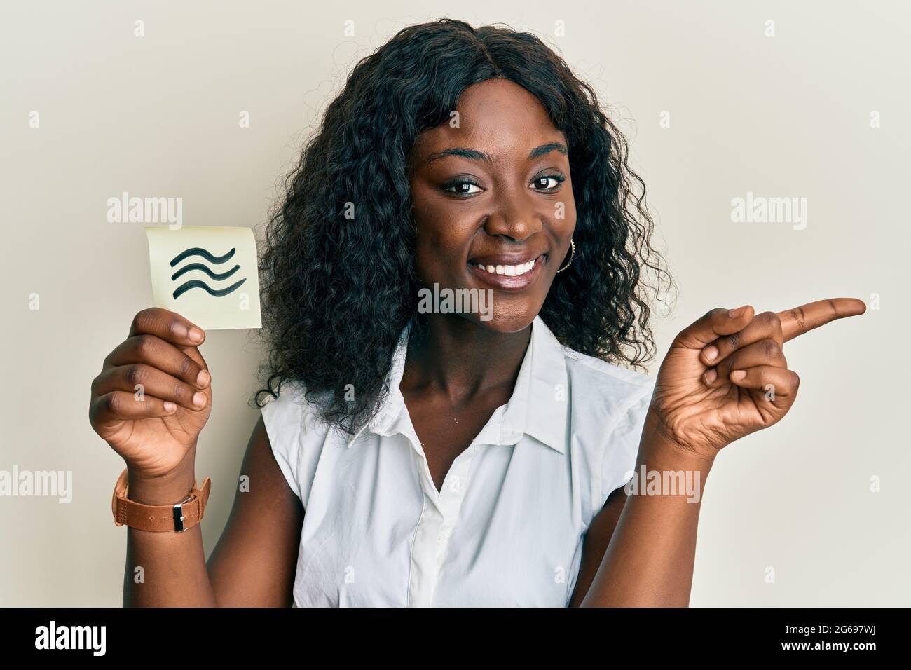 Beautiful african young woman holding paper with aquarius zodiac sign ...