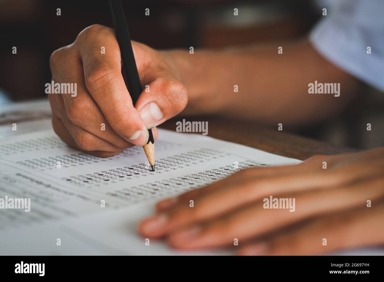 Students writing and reading exam answer sheets exercises in classroom ...