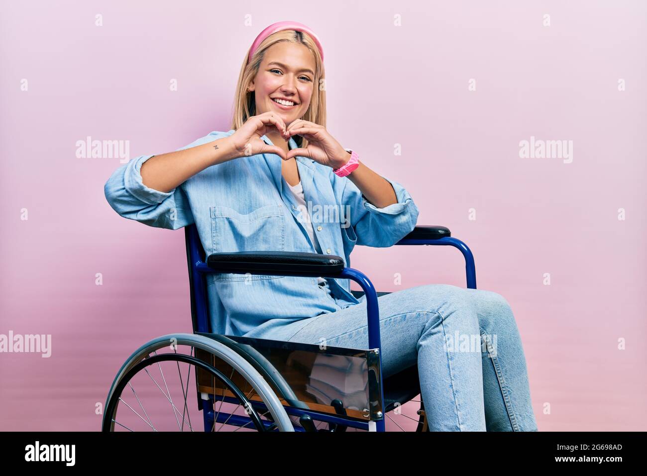 Beautiful blonde woman sitting on wheelchair smiling in love doing ...
