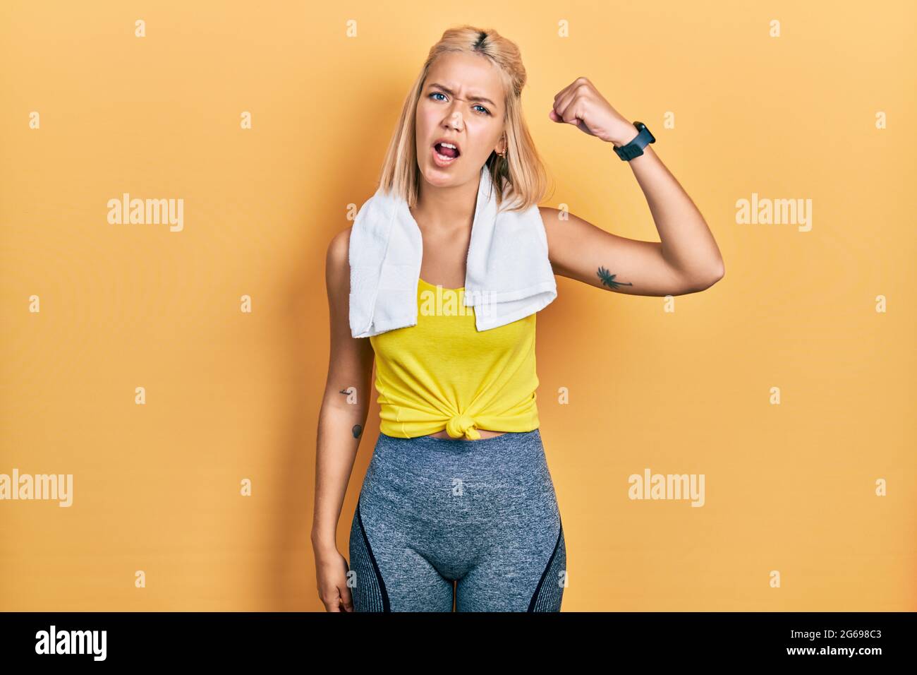 Beautiful blonde sports woman wearing workout outfit angry and mad ...