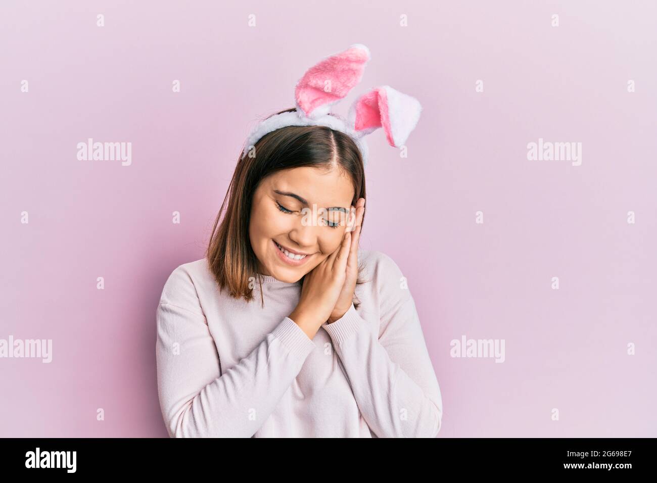 Young beautiful woman wearing cute easter bunny ears sleeping tired ...