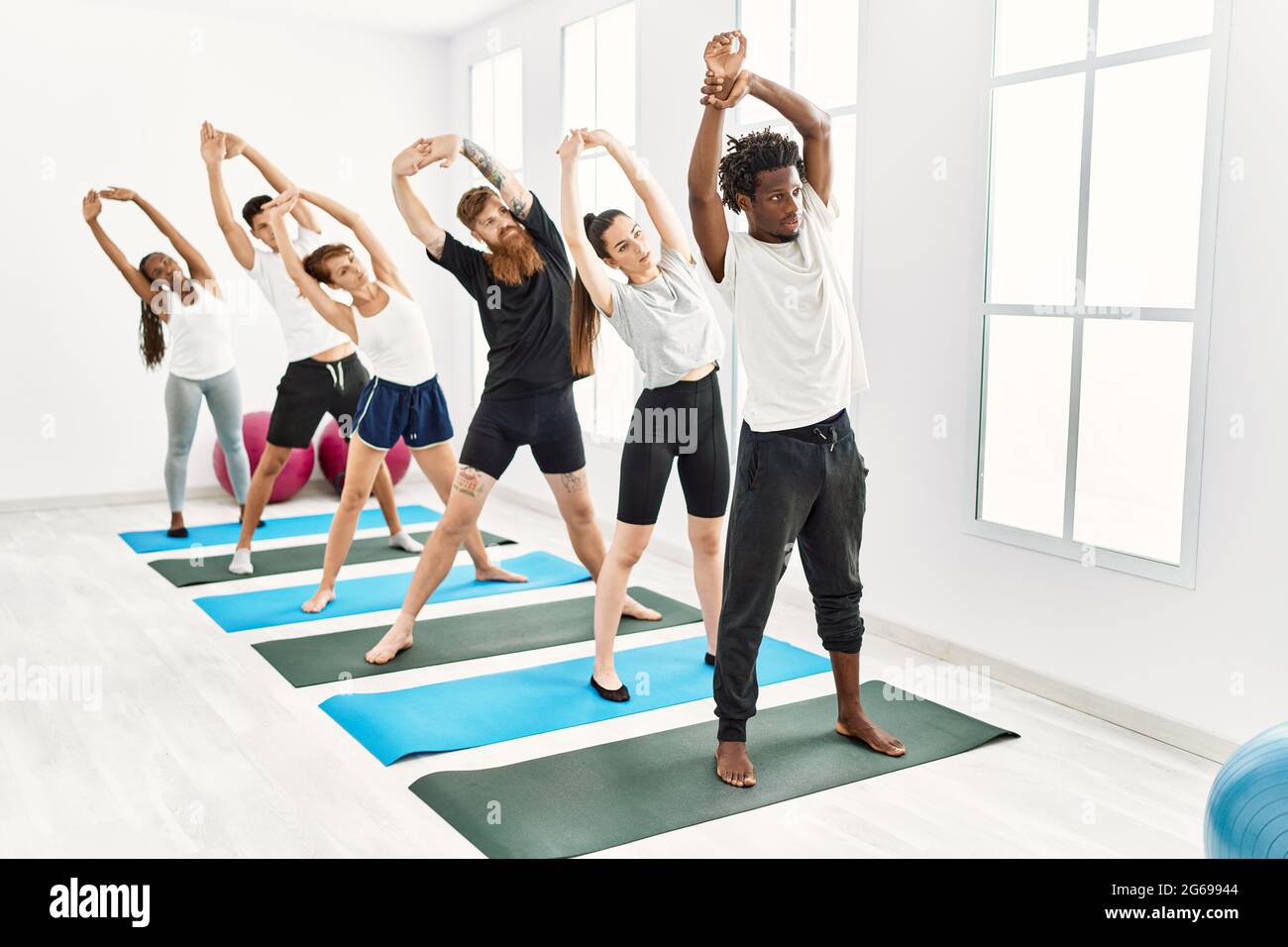 Group of young people concentrate stretching at sport center Stock ...