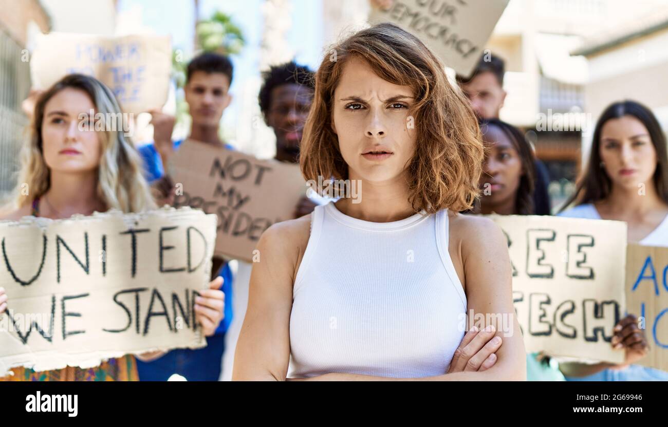 Young activist woman with arms crossed gesture standing with a group of ...