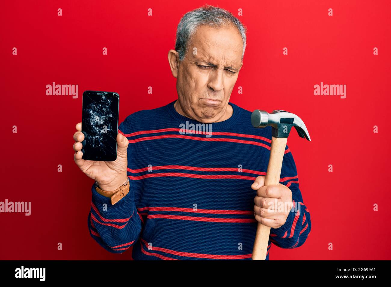Senior hispanic man holding broken smartphone showing cracked screen ...