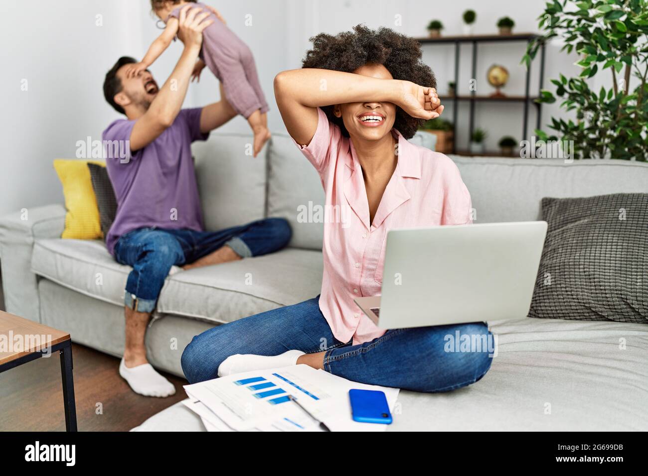 Mother of interracial family working using computer laptop at home ...