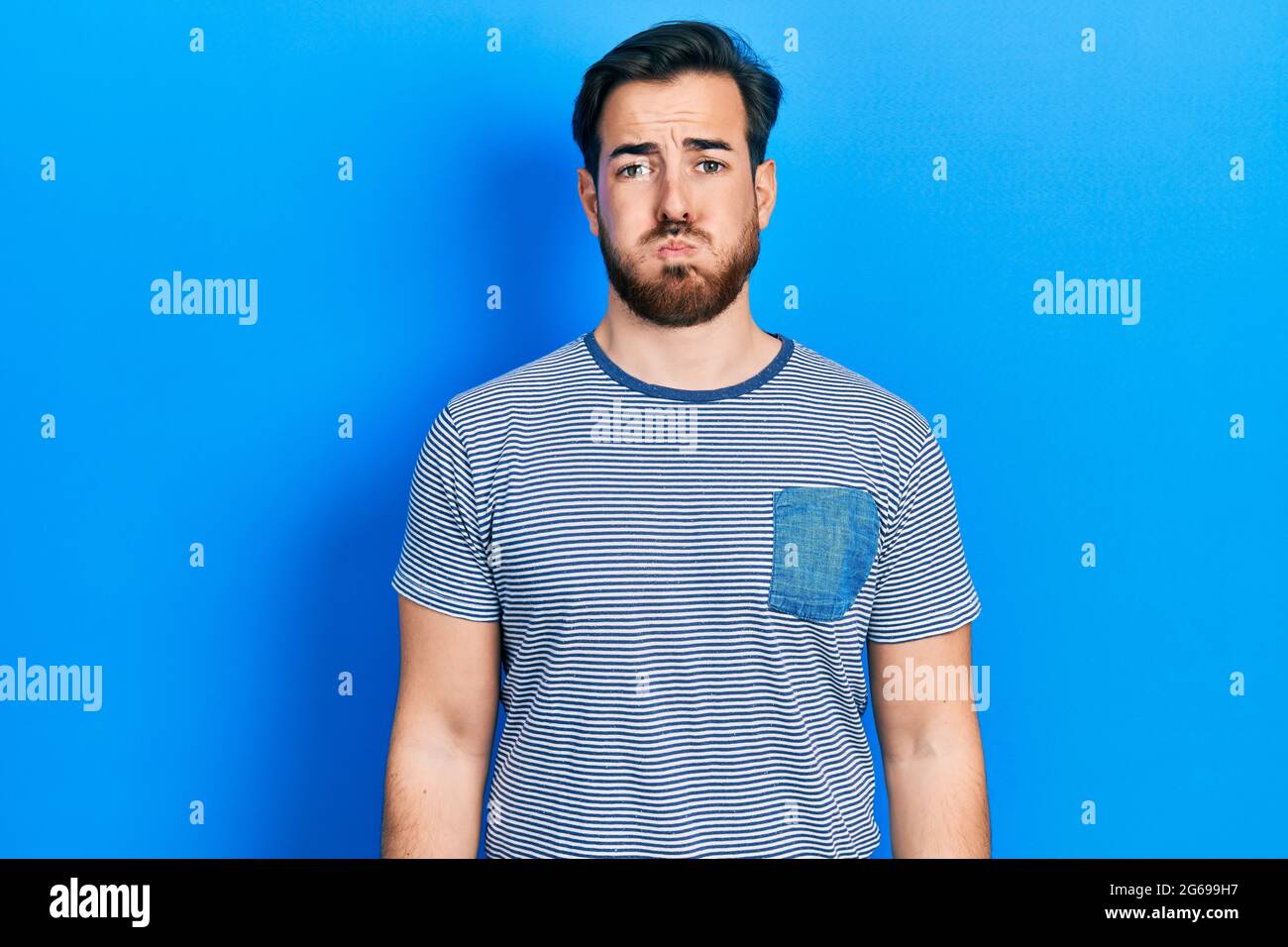 Handsome caucasian man with beard wearing casual striped t shirt ...