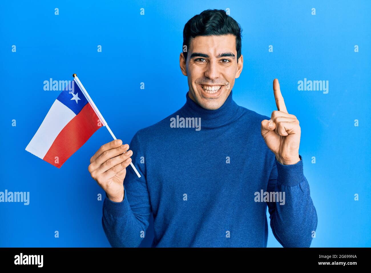 Handsome hispanic business man holding chile flag smiling with an idea ... Handsome hispanic business man holding chile flag smiling with an idea ...