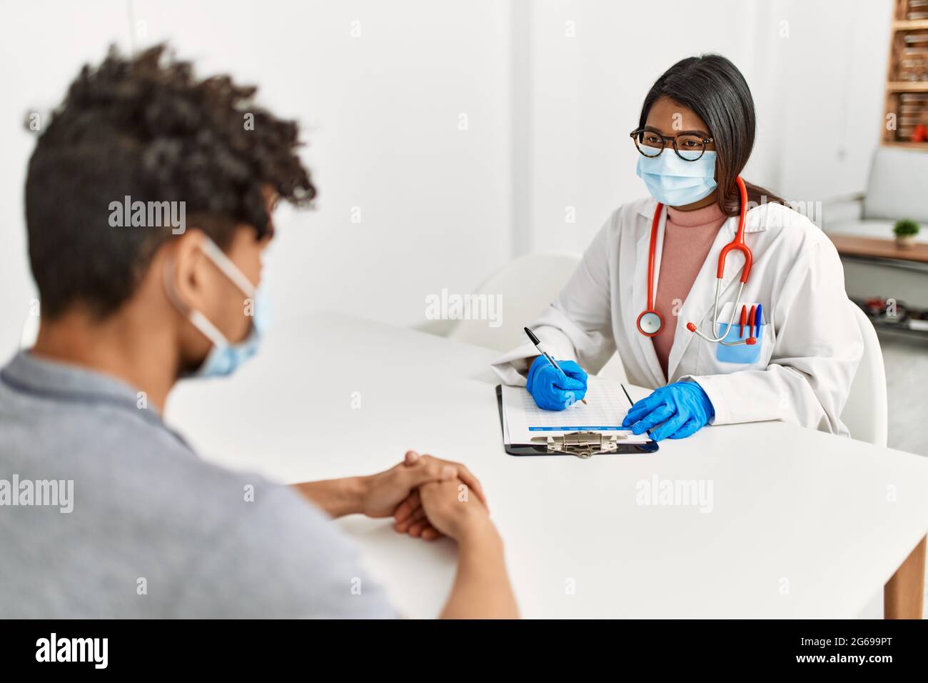 Young latin doctor woman speaking in medical consultation at the clinic ...