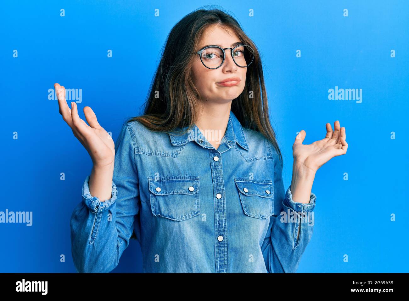 Young caucasian woman wearing casual clothes and glasses clueless and ...