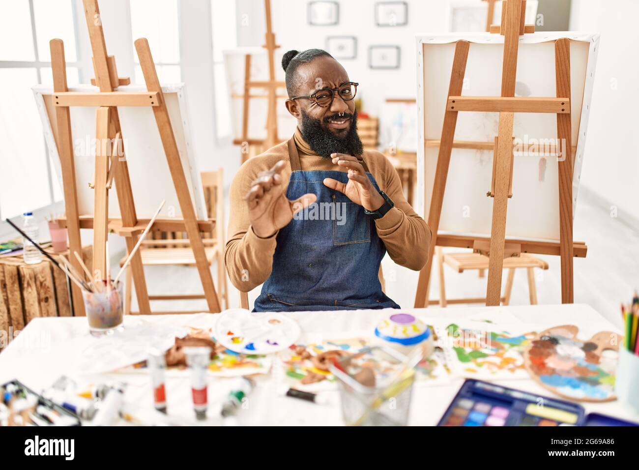 African american artist man at art studio disgusted expression ...