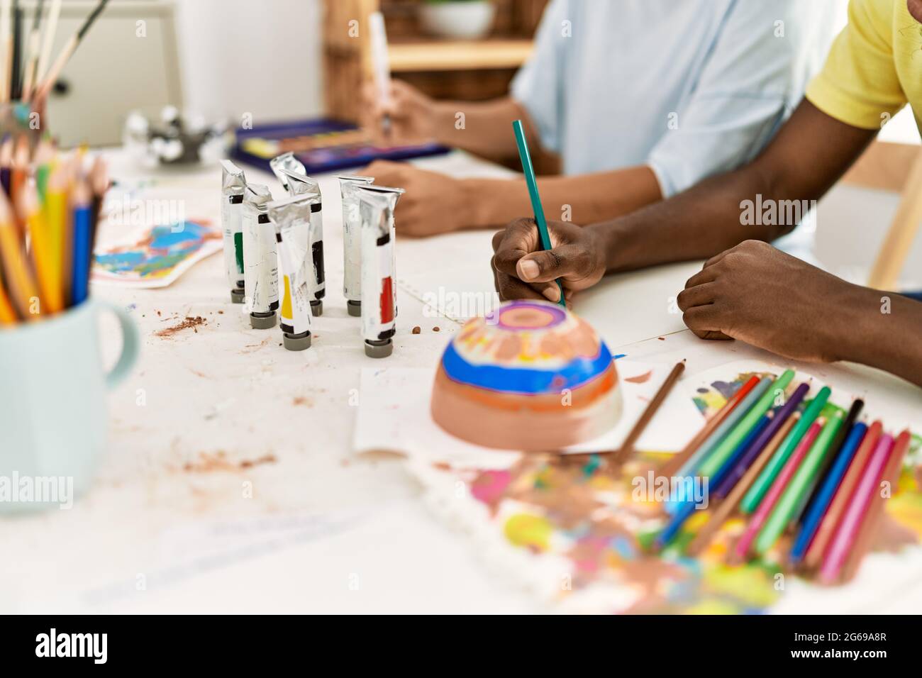 African american artist couple painting sitting on the table at art ...