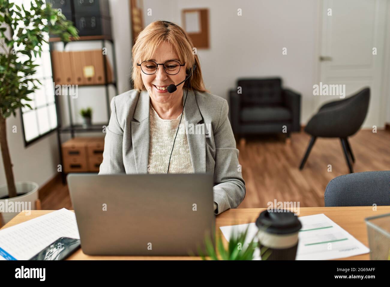 Middle age call center agent working at the office Stock Photo - Alamy