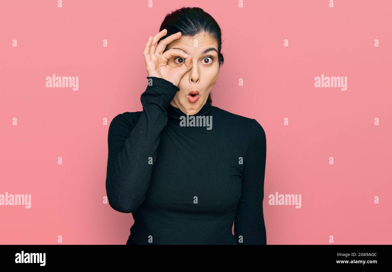 Young hispanic woman wearing casual clothes doing ok gesture shocked ...