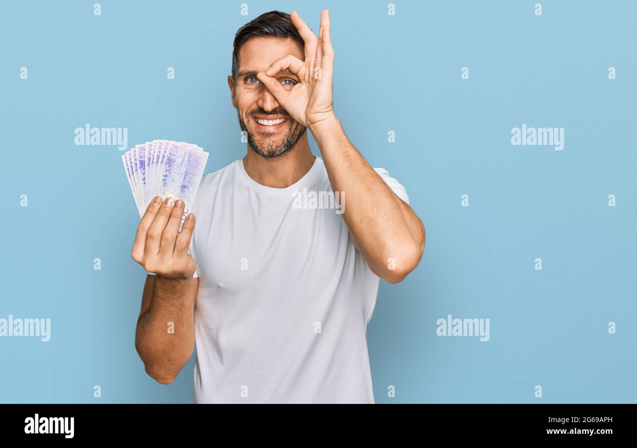 Handsome man with beard holding 20 swedish krona banknotes smiling ...