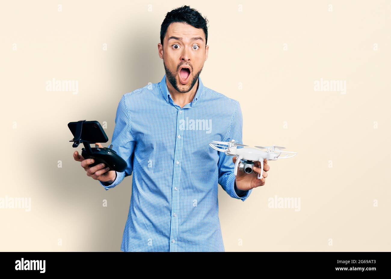 Hispanic man with beard using drone with remote control afraid and ...