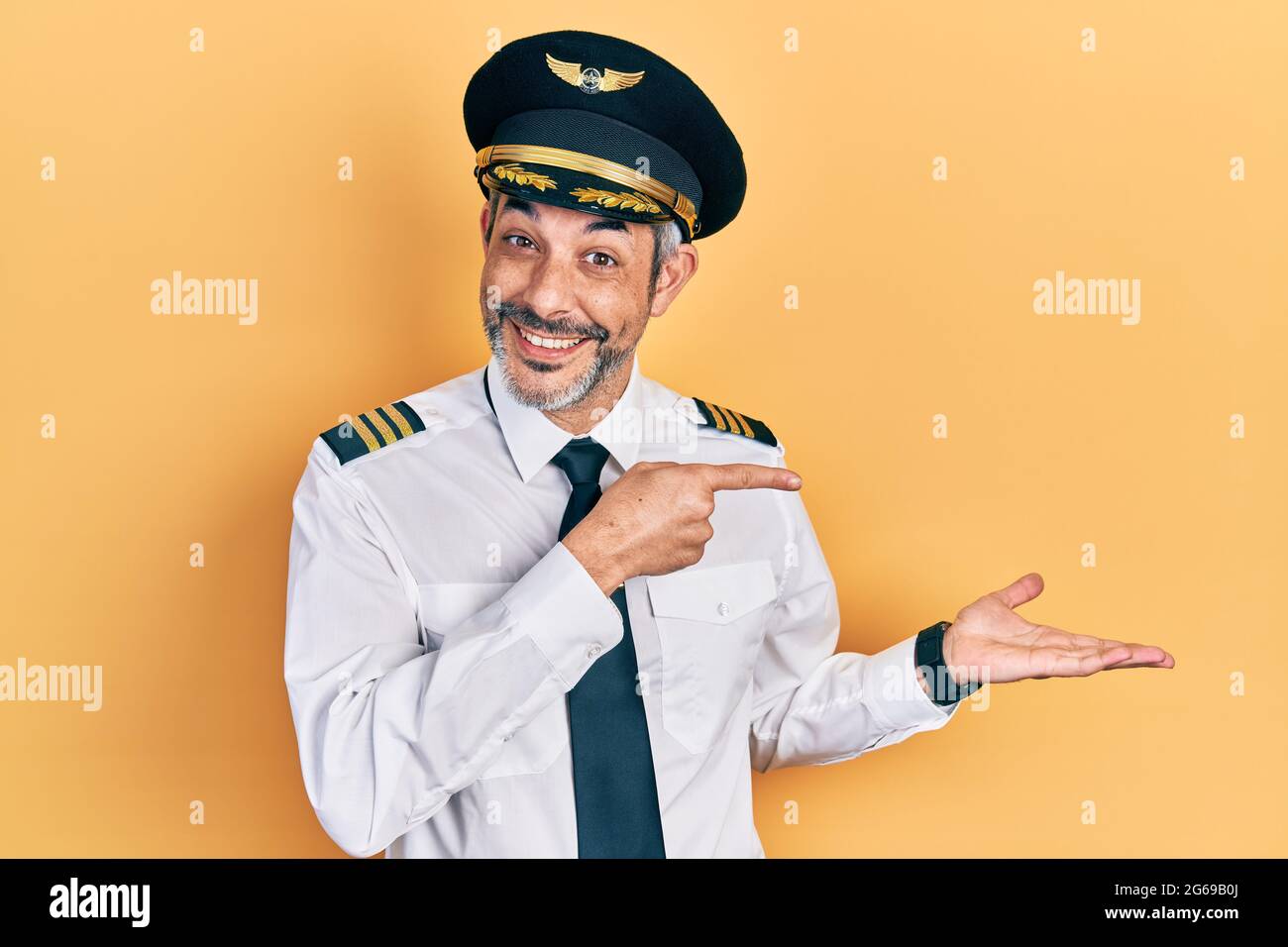 Handsome middle age man with grey hair wearing airplane pilot uniform ...