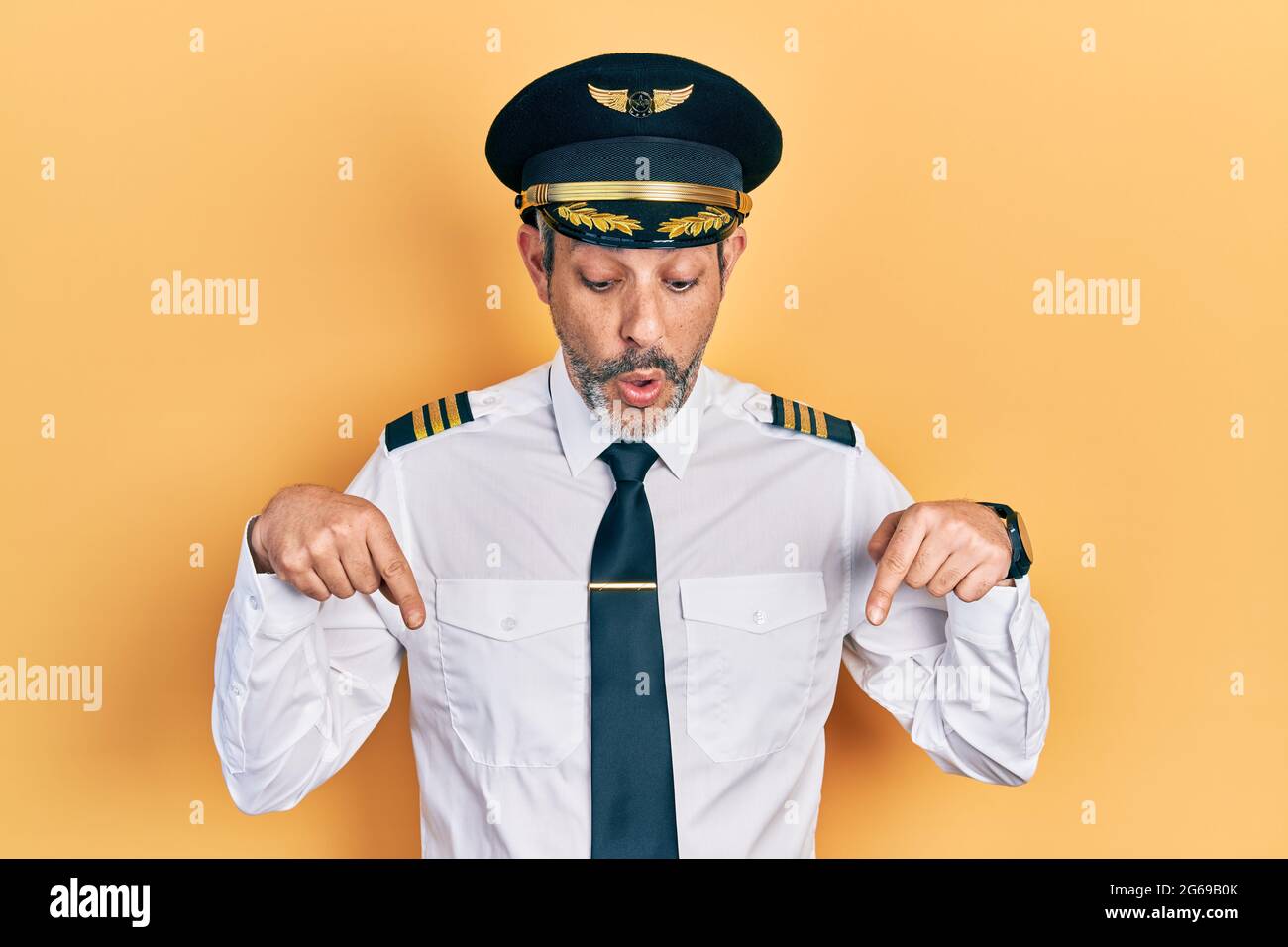 Handsome middle age man with grey hair wearing airplane pilot uniform ...