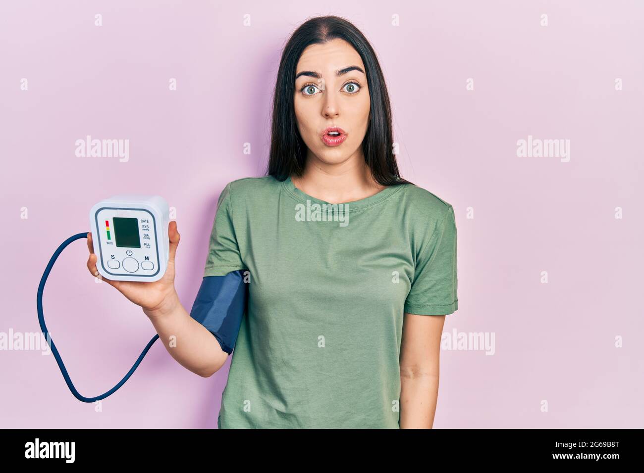 Beautiful woman with blue eyes using glucose meter scared and amazed ...