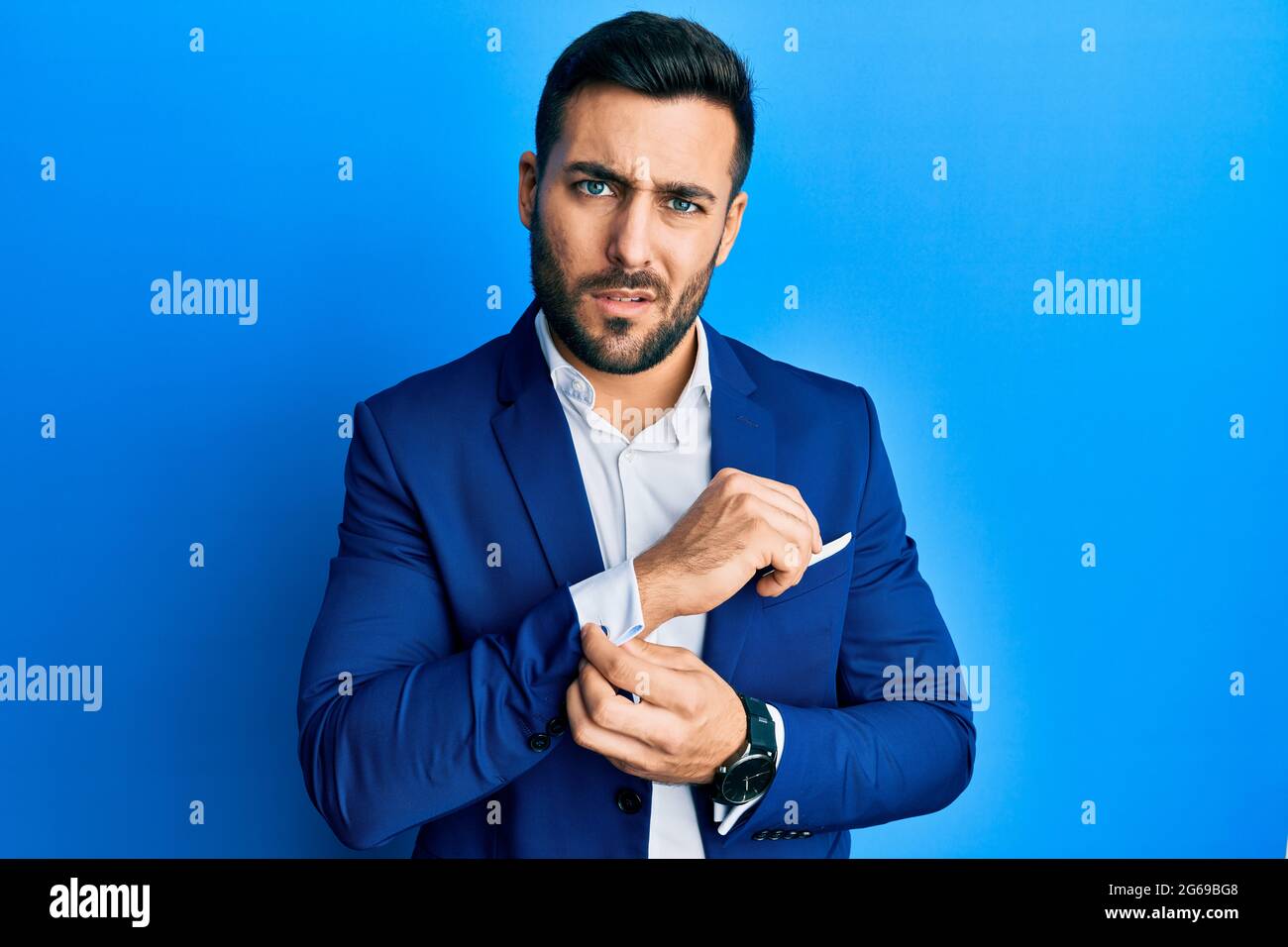Young hispanic businessman wearing business jacket putting on shirt ...