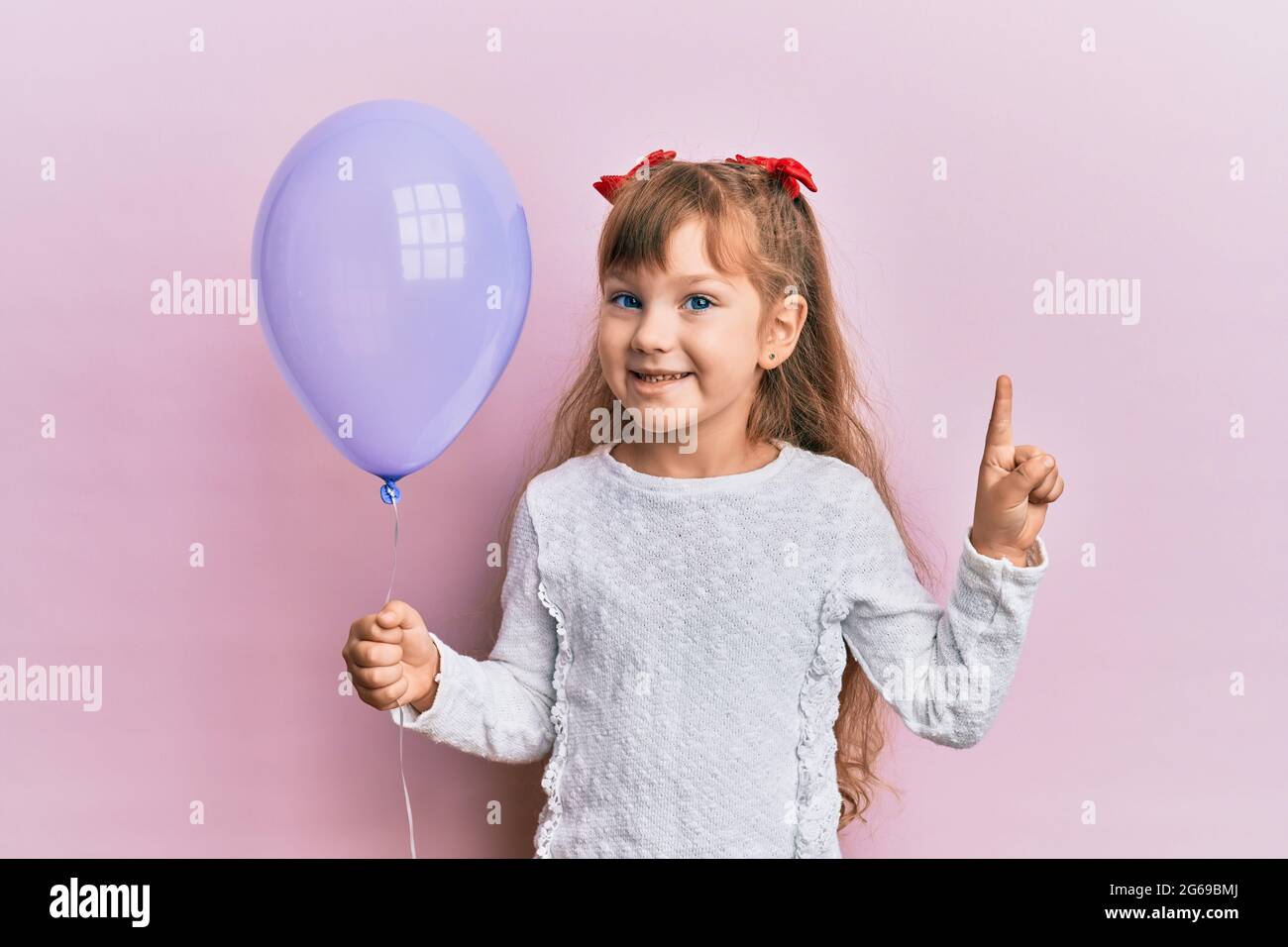 Child pointing pink balloon hi-res stock photography and images - Alamy