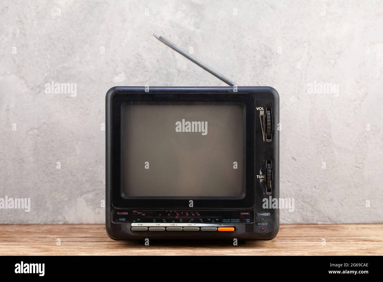 Vintage retro analog small TV set stand on wooden floor front grey ...