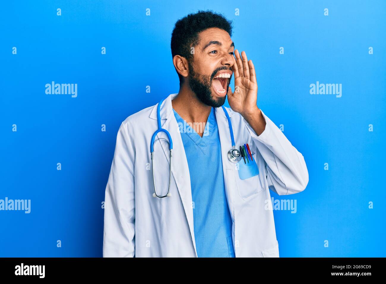 Handsome hispanic man with beard wearing doctor uniform and stethoscope ...