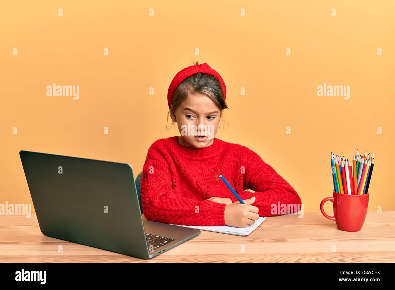 Little beautiful girl studying using computer laptop skeptic and ...