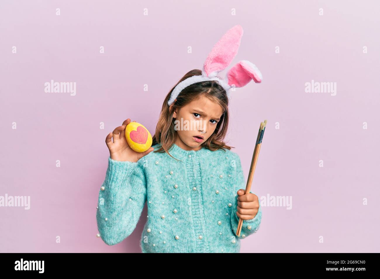 Little beautiful girl wearing cute easter bunny ears holding colored ...