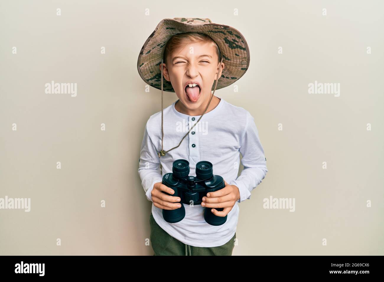 Little caucasian boy kid wearing explorer hat holding binoculars ...
