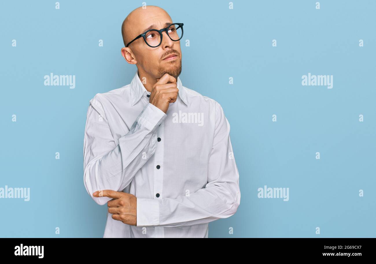 Bald man with beard wearing business shirt and glasses with hand on ...