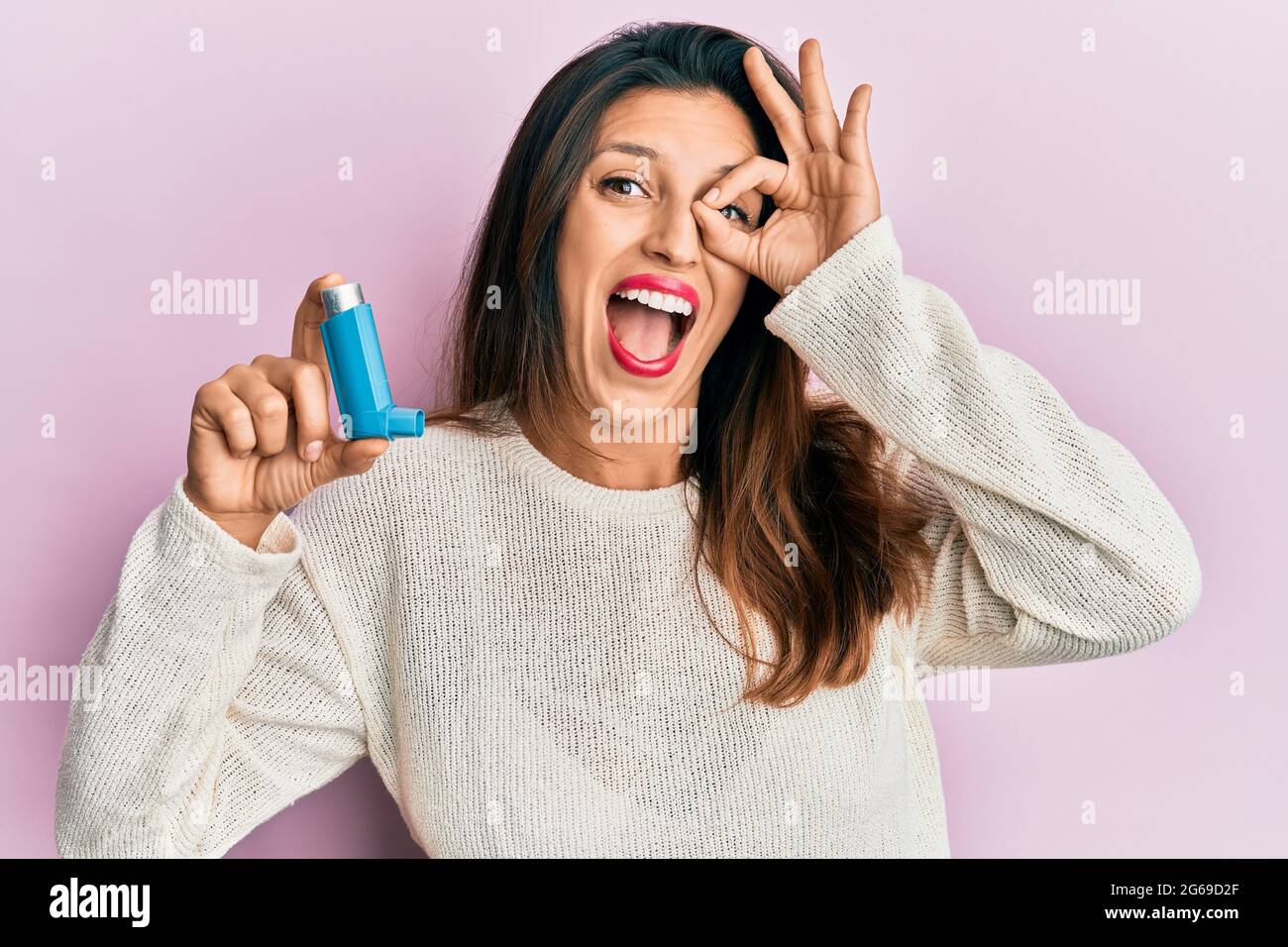 Beautiful hispanic woman holding medical asthma inhaler smiling happy ...