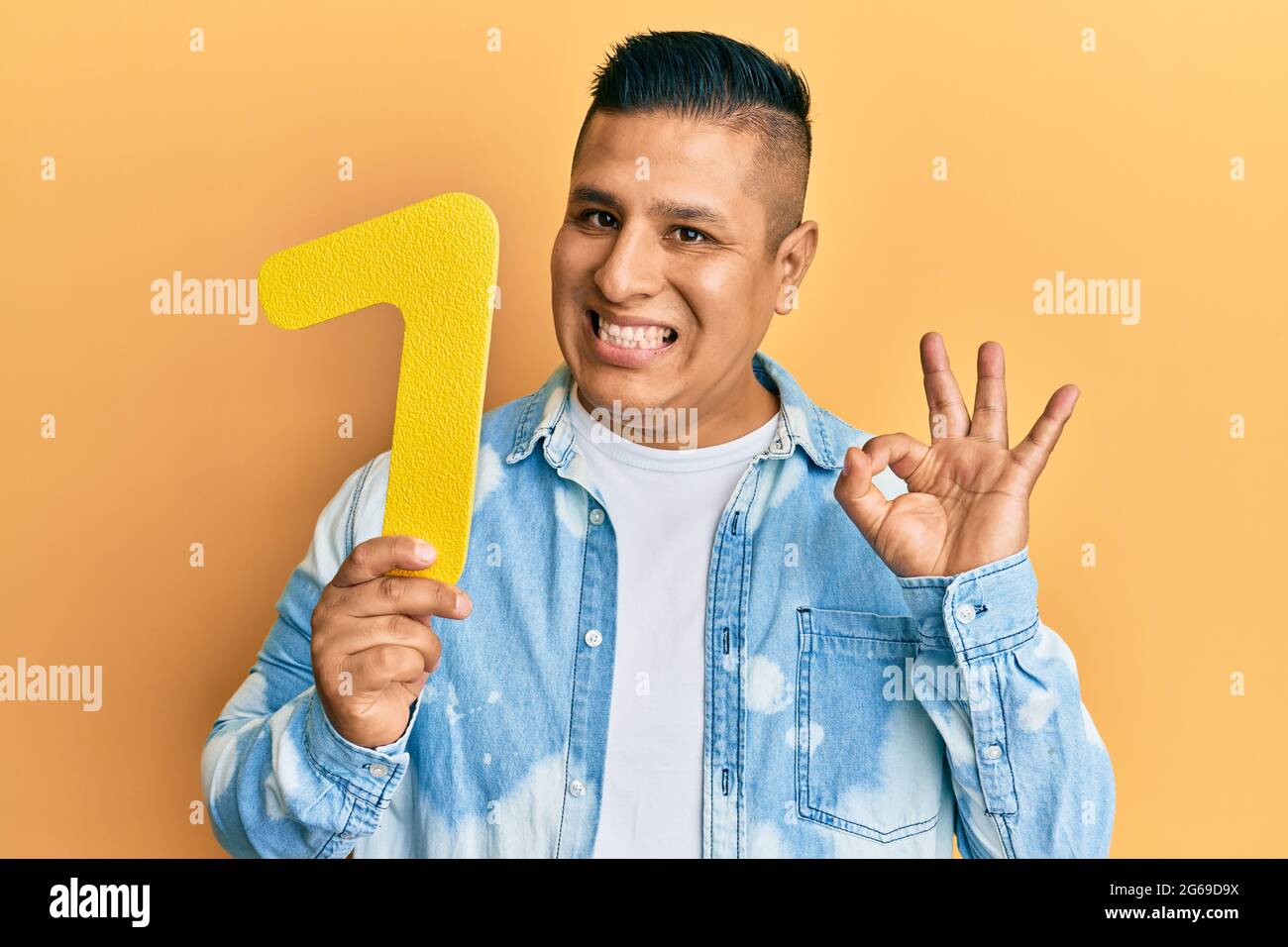 Young latin man holding number one doing ok sign with fingers, smiling ...