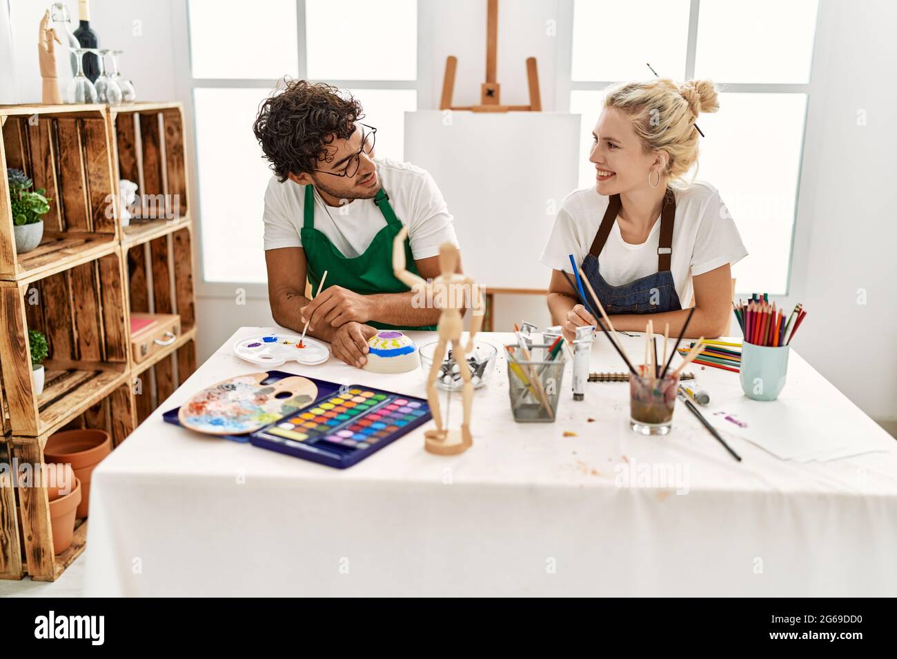 Young artist couple smiling happy painting at art studio Stock Photo ...