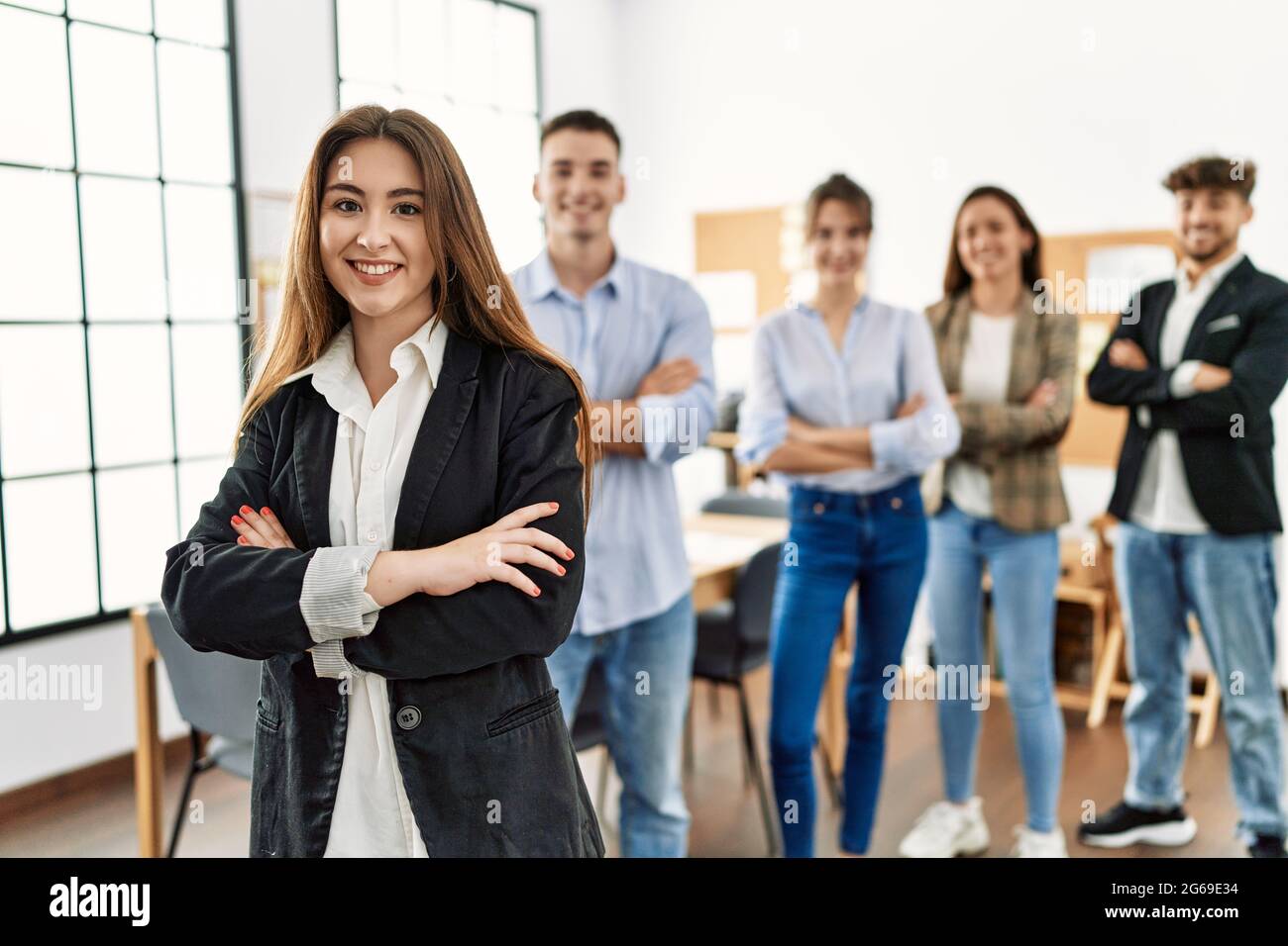 Group of young business workers smiling happy standing with arms ...
