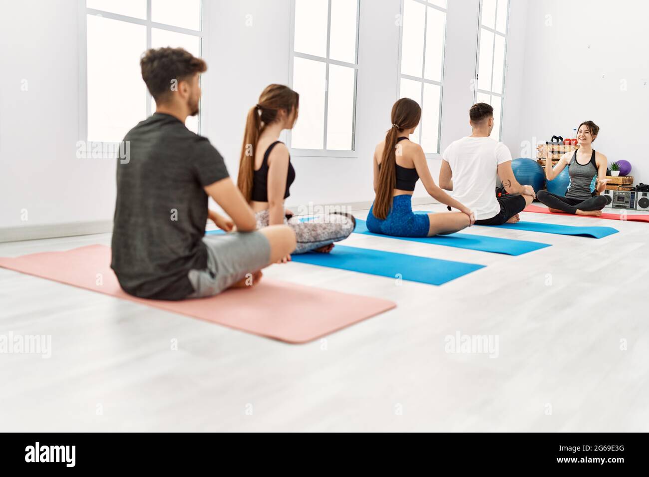 Group of young people having yoga class with personal trainer at sport ...