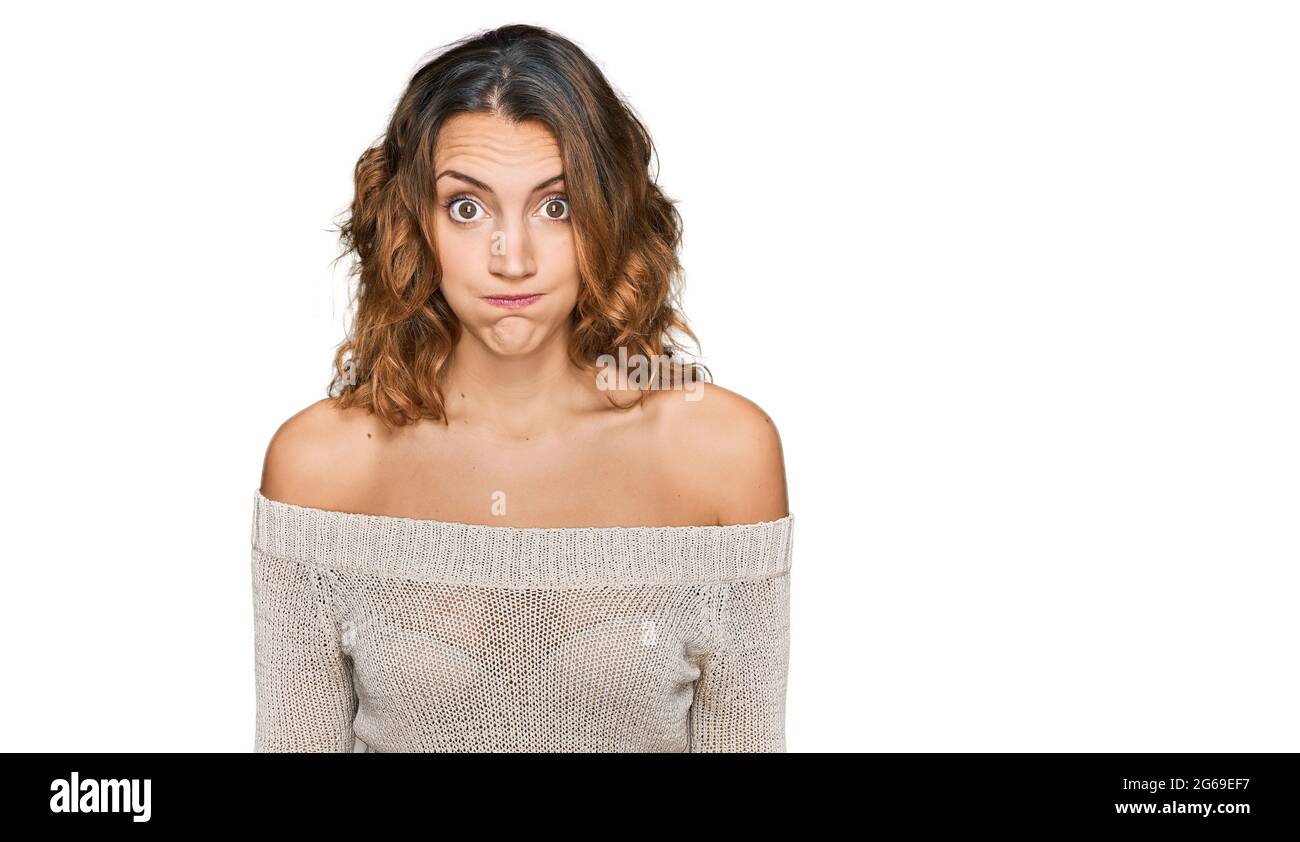 Beautiful young caucasian woman wearing casual clothes puffing cheeks ...